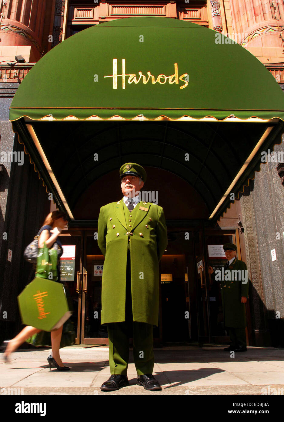 A Harrods 'Greenman' stands to attention at Door 3 as a customer ...