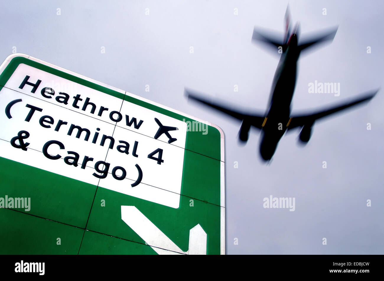 An aeroplane flying above road signs near Heathrow International ...