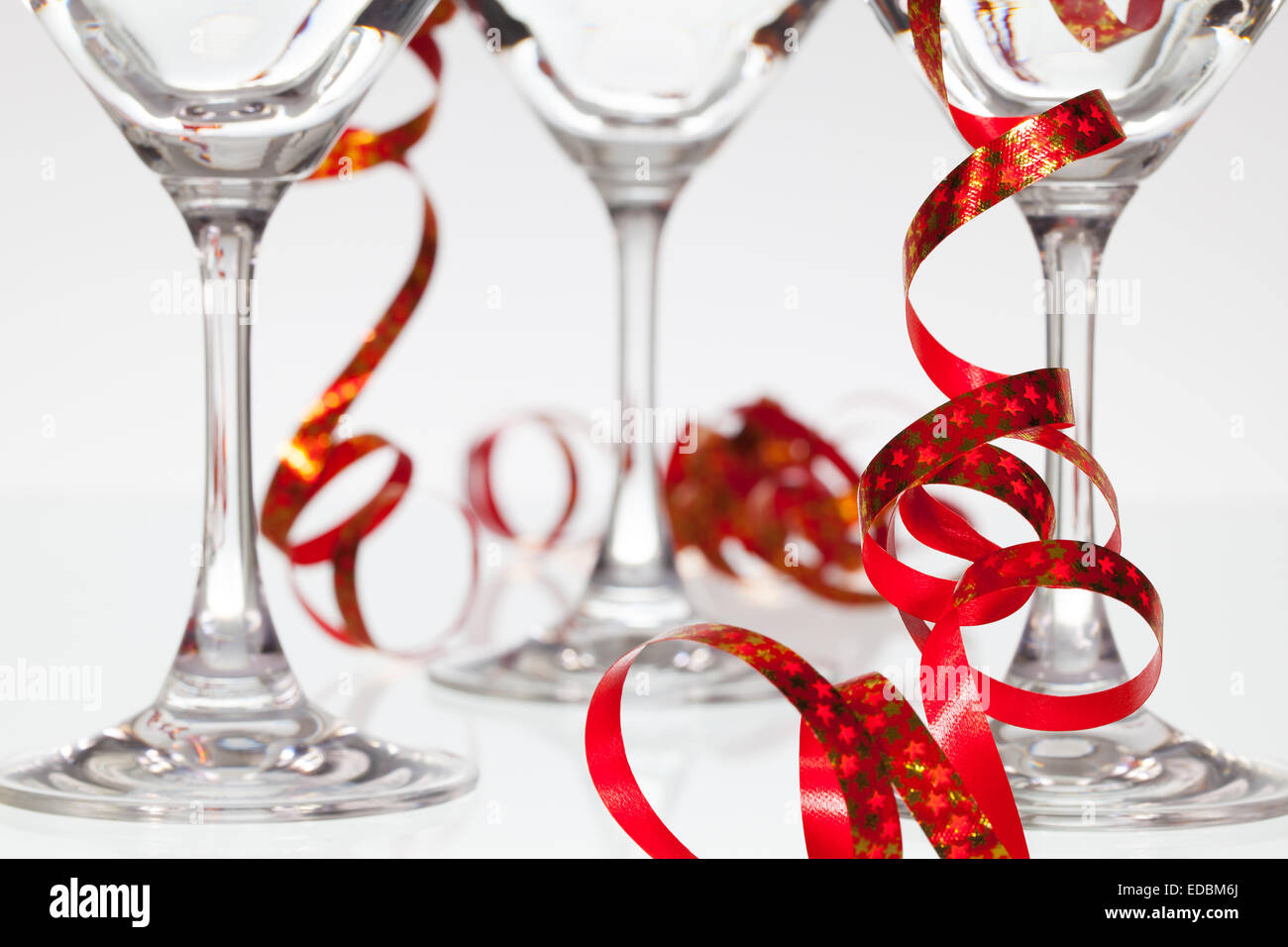 Three empty glasses on champagne and red ribbon Stock Photo - Alamy