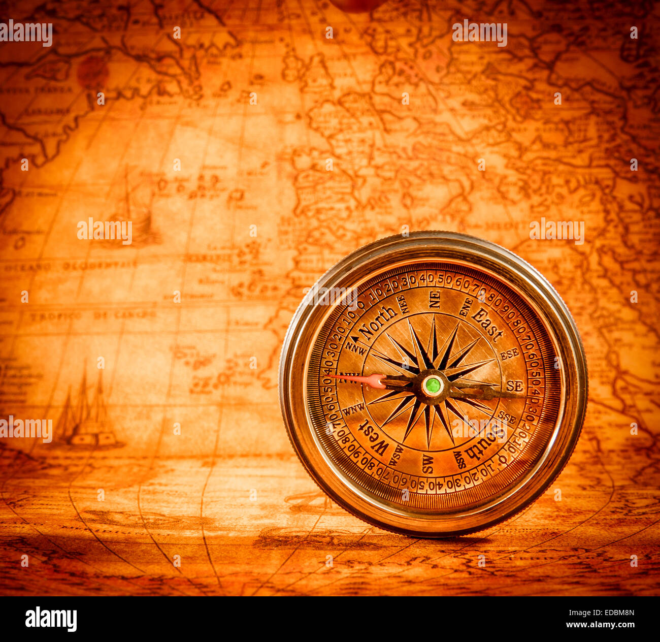 Vintage still life. Vintage compass lies on an ancient world map in ...