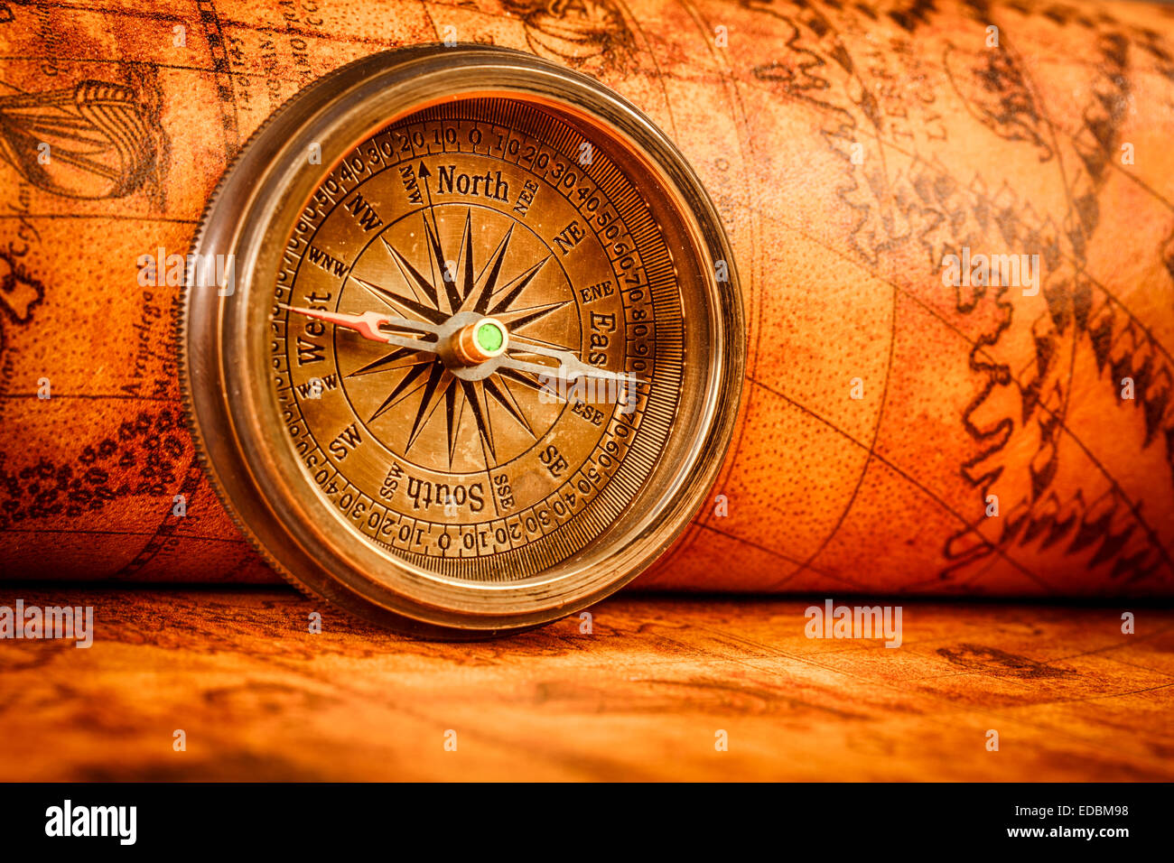 Vintage still life. Vintage compass lies on an ancient world map in ...