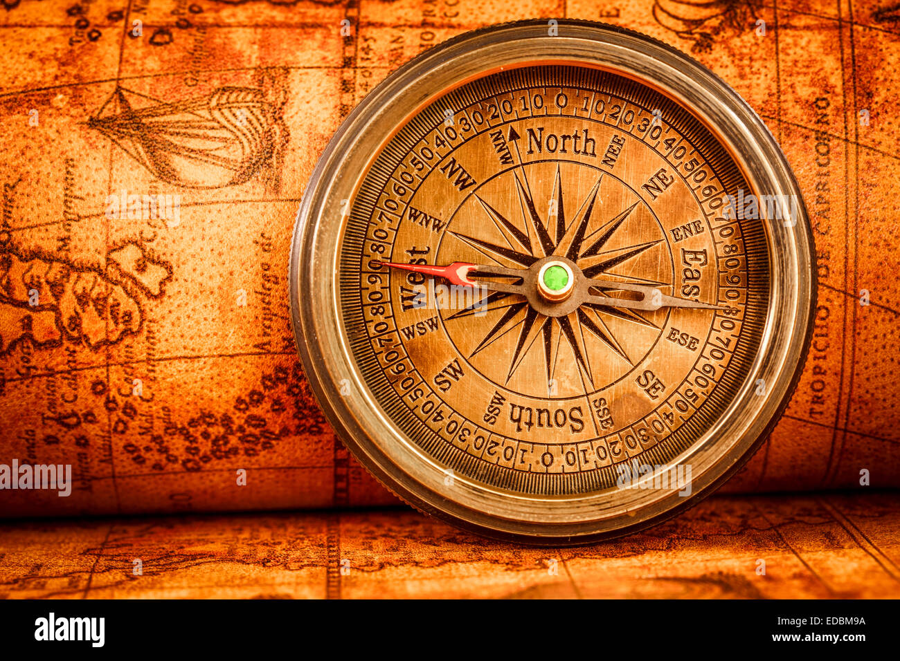 Vintage still life. Vintage compass lies on an ancient world map in ...