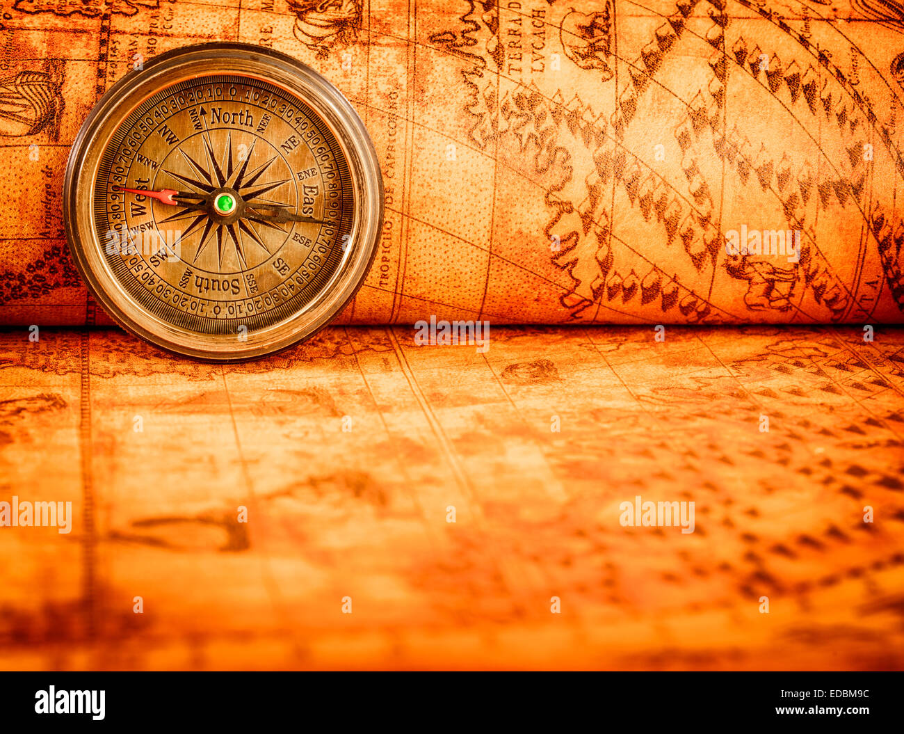 Vintage still life. Vintage compass lies on an ancient world map in ...