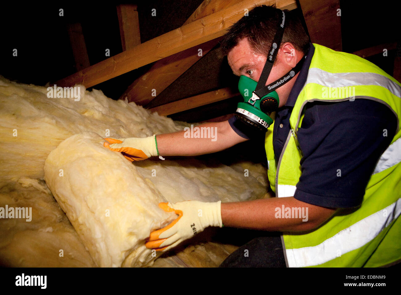 Illustrative image of loft insulation. A worker from Total Insulation ...
