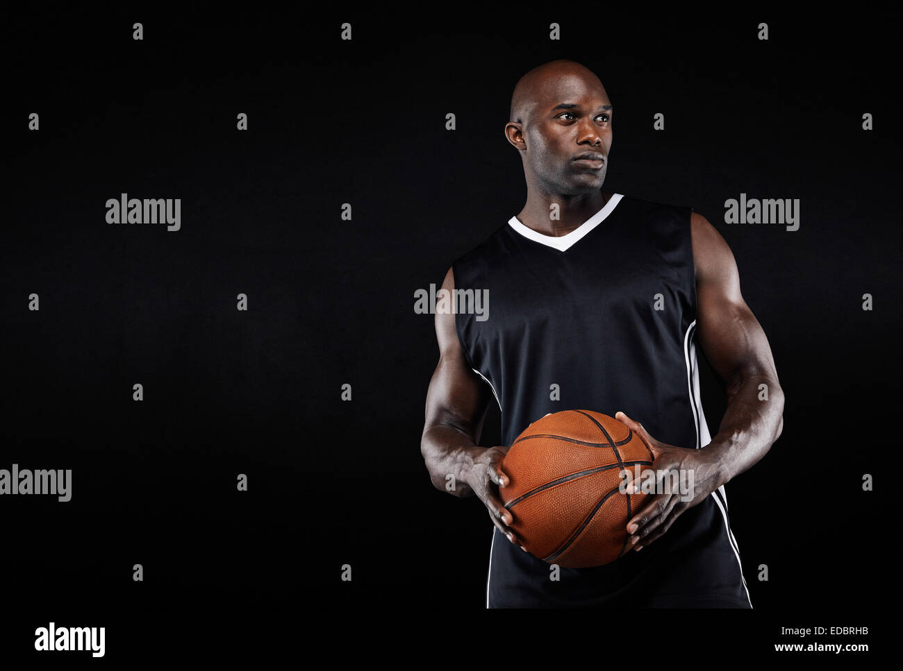 Image of fit young Afro American athlete holding a basketball looking ...