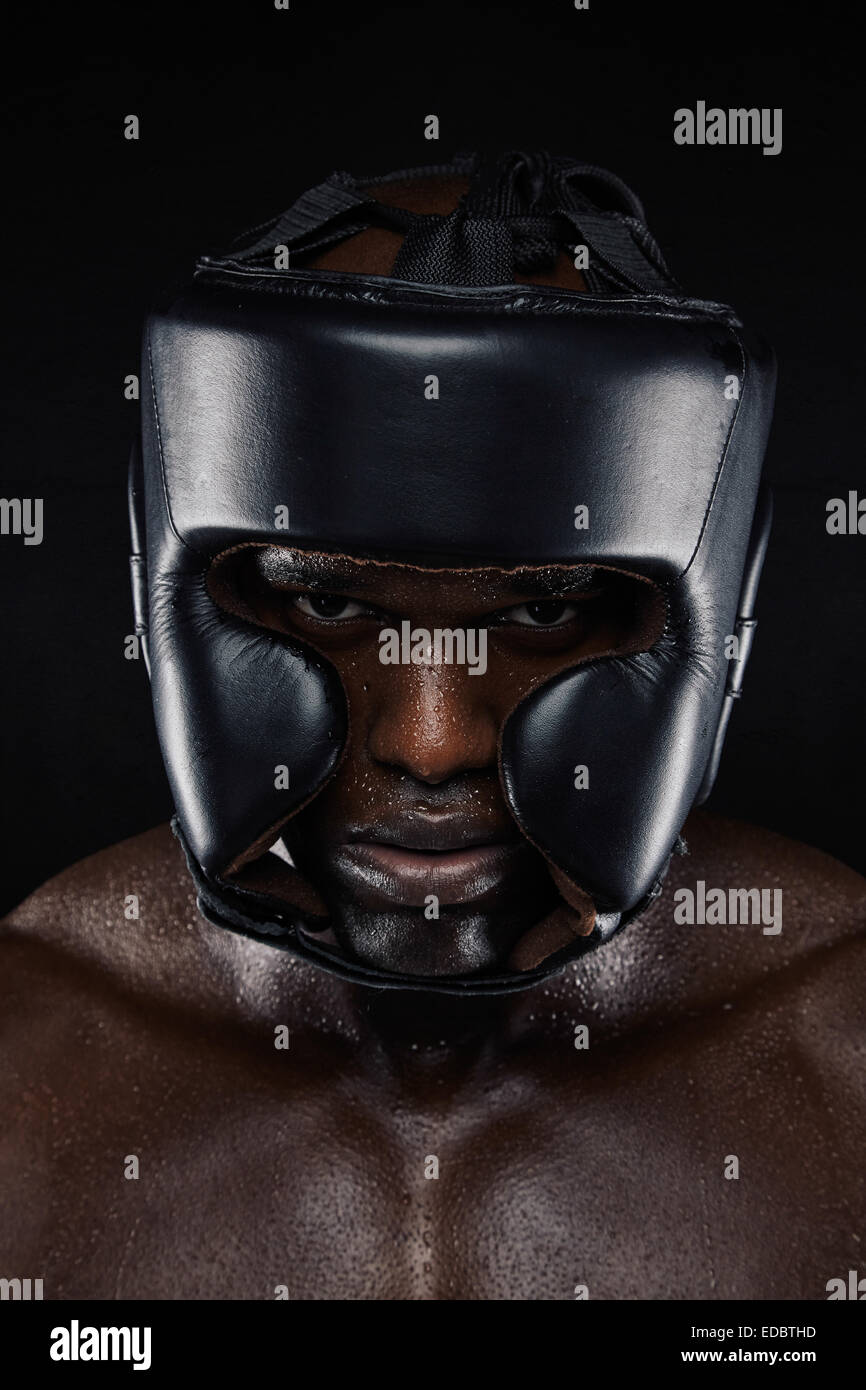 Close-up portrait of strong African man wearing head protector against ...
