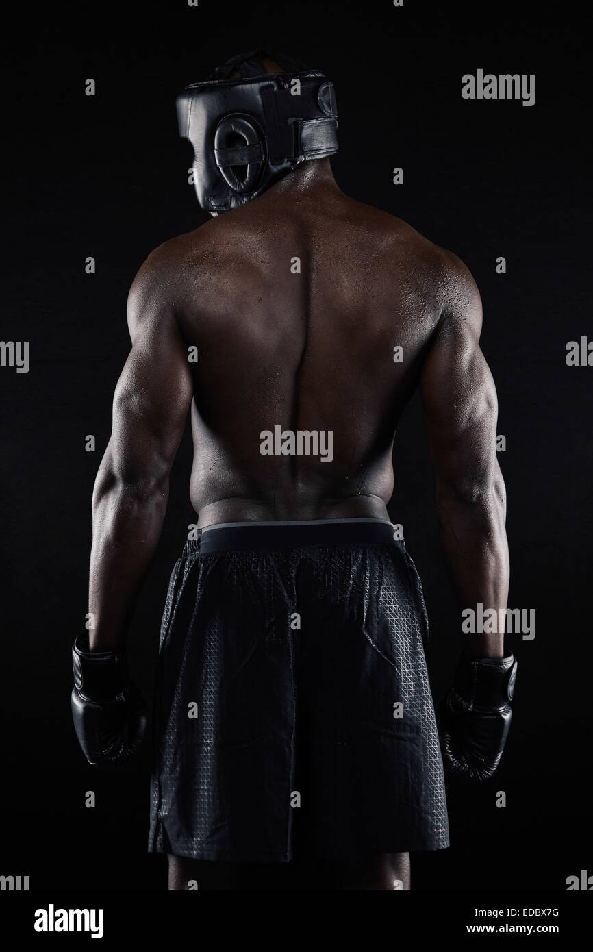 Back of strong young male boxer on black background. Young African male ...