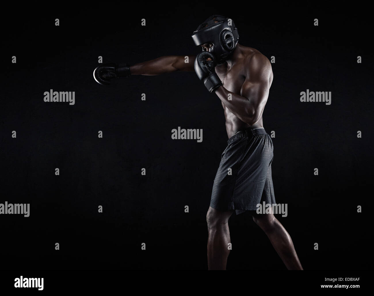 Side view of muscular man boxing on black background. Afro American ...
