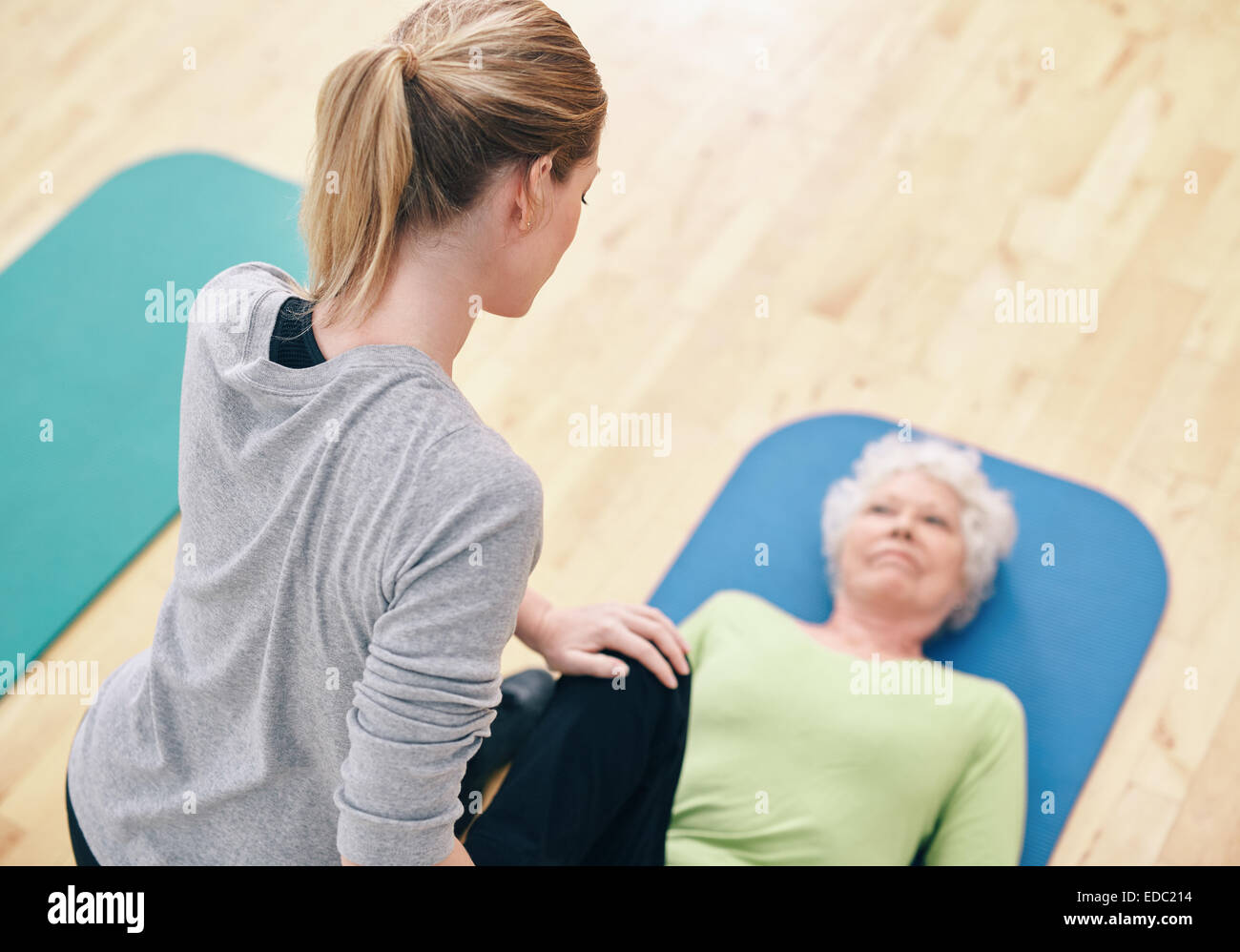 Instructor helping client stretch leg hi-res stock photography and ...