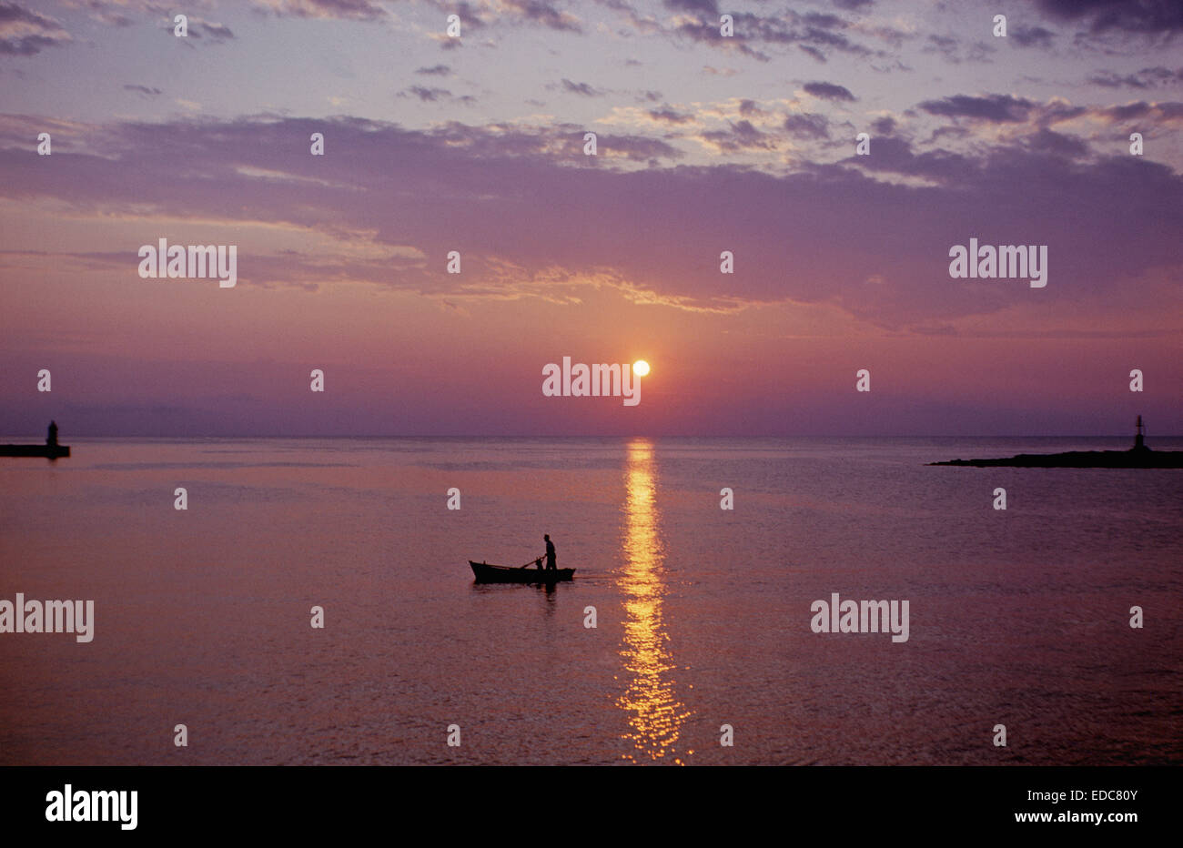 lone oarsman in his boat pictured against setting sun Stock Photo - Alamy