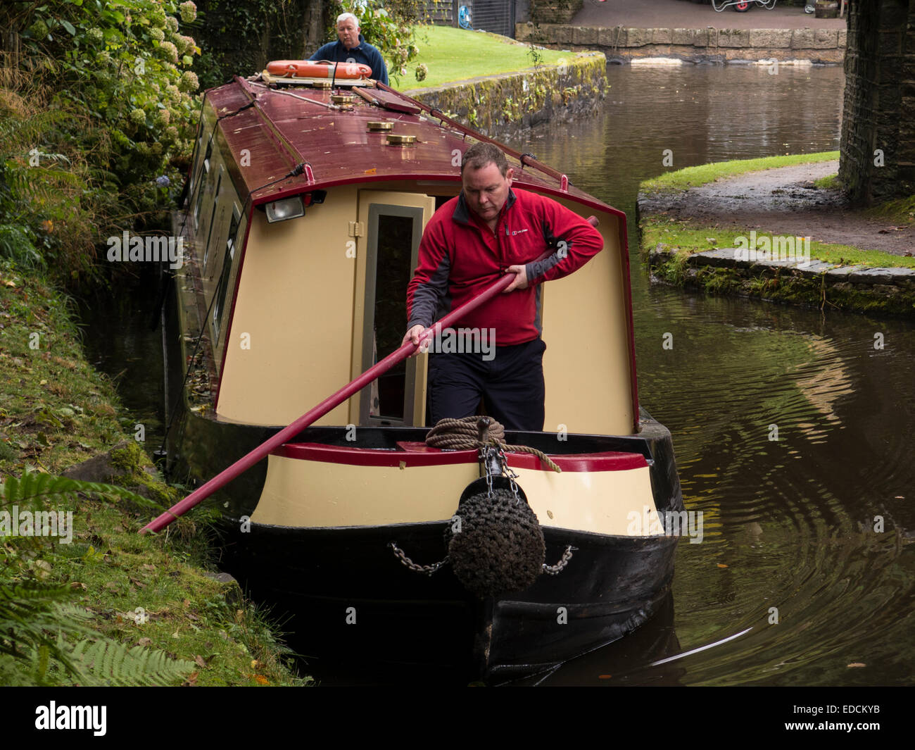 narrow boat owner poles off the boat from the side of the canal,at ...