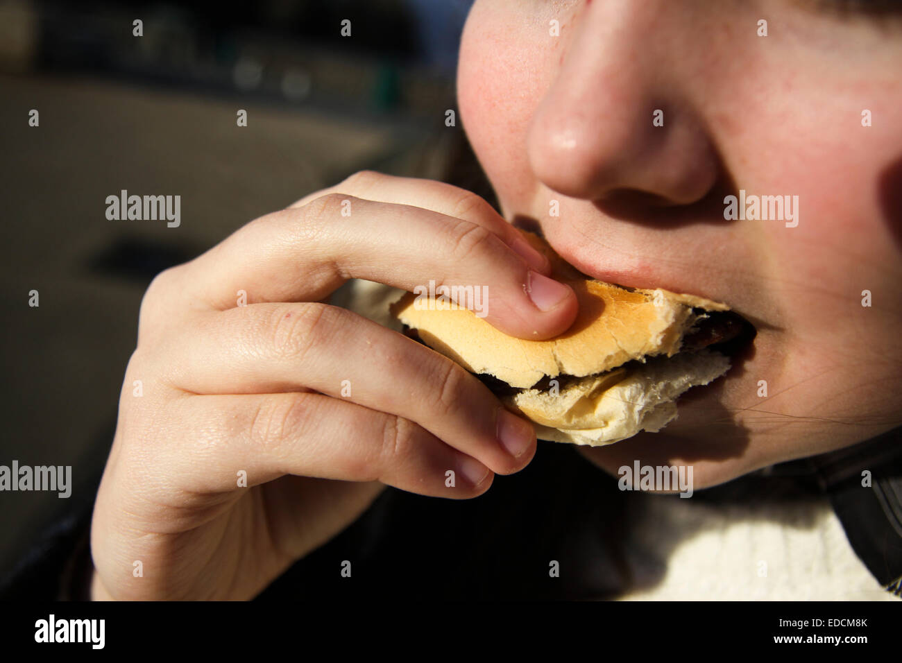 Young girl eating ham roll Stock Photo - Alamy