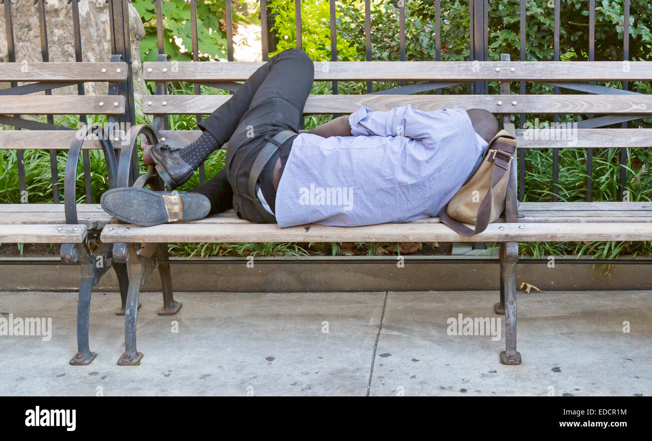 A man sleeping on a city park bench Stock Photo - Alamy