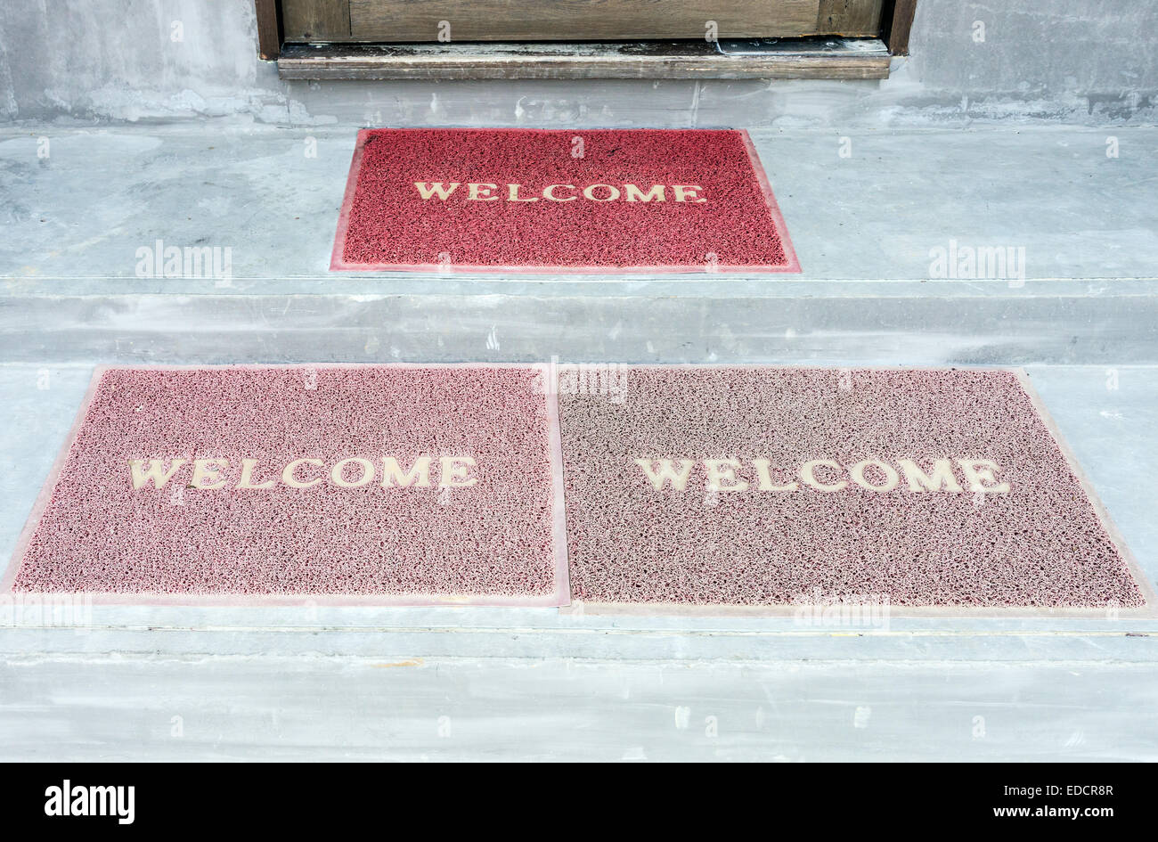 Old welcome doormat on the stair of guest house Stock Photo - Alamy