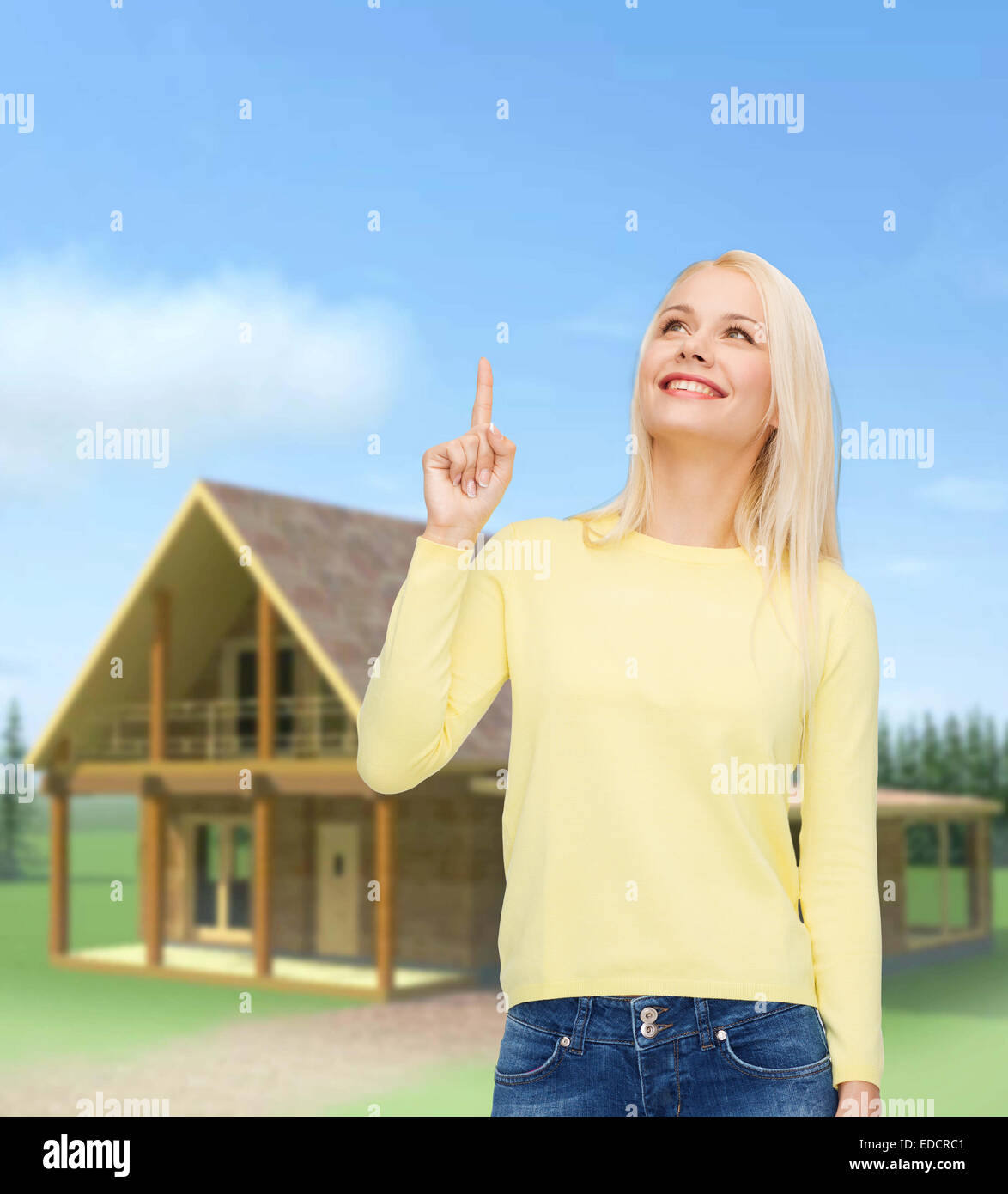 smiling woman pointing her finger up Stock Photo - Alamy