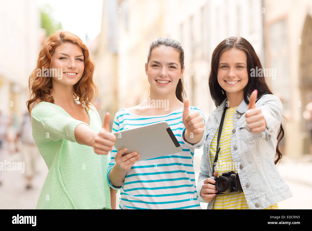 smiling teenage girls with tablet pc and camera Stock Photo - Alamy