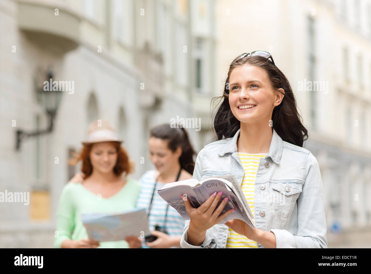 smiling teenage girls with city guides and camera Stock Photo - Alamy