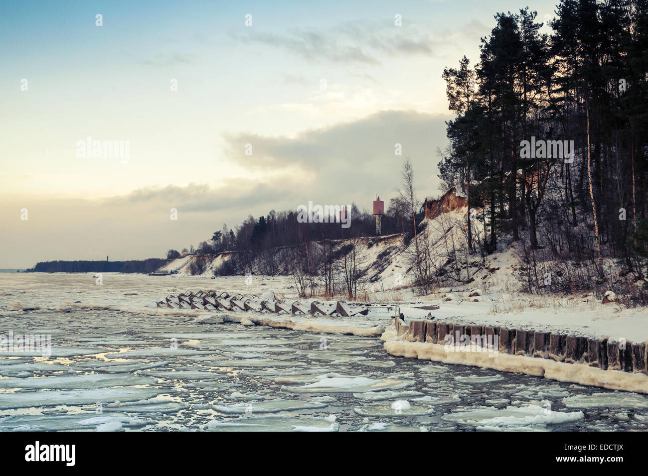 Winter coastal landscape with floating ice and frozen pier. Gulf of ...