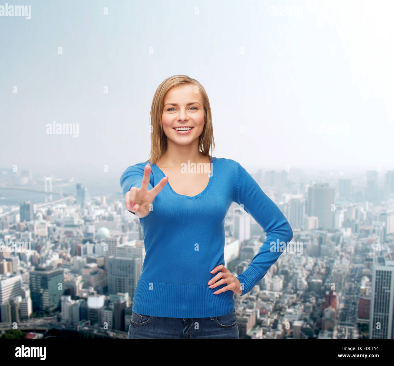 smiling teenage girl showing v-sign with hand Stock Photo - Alamy