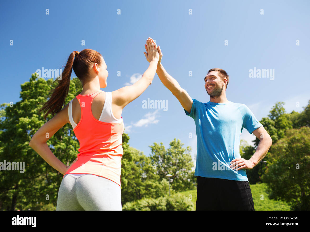 two smiling people making high five outdoors Stock Photo - Alamy