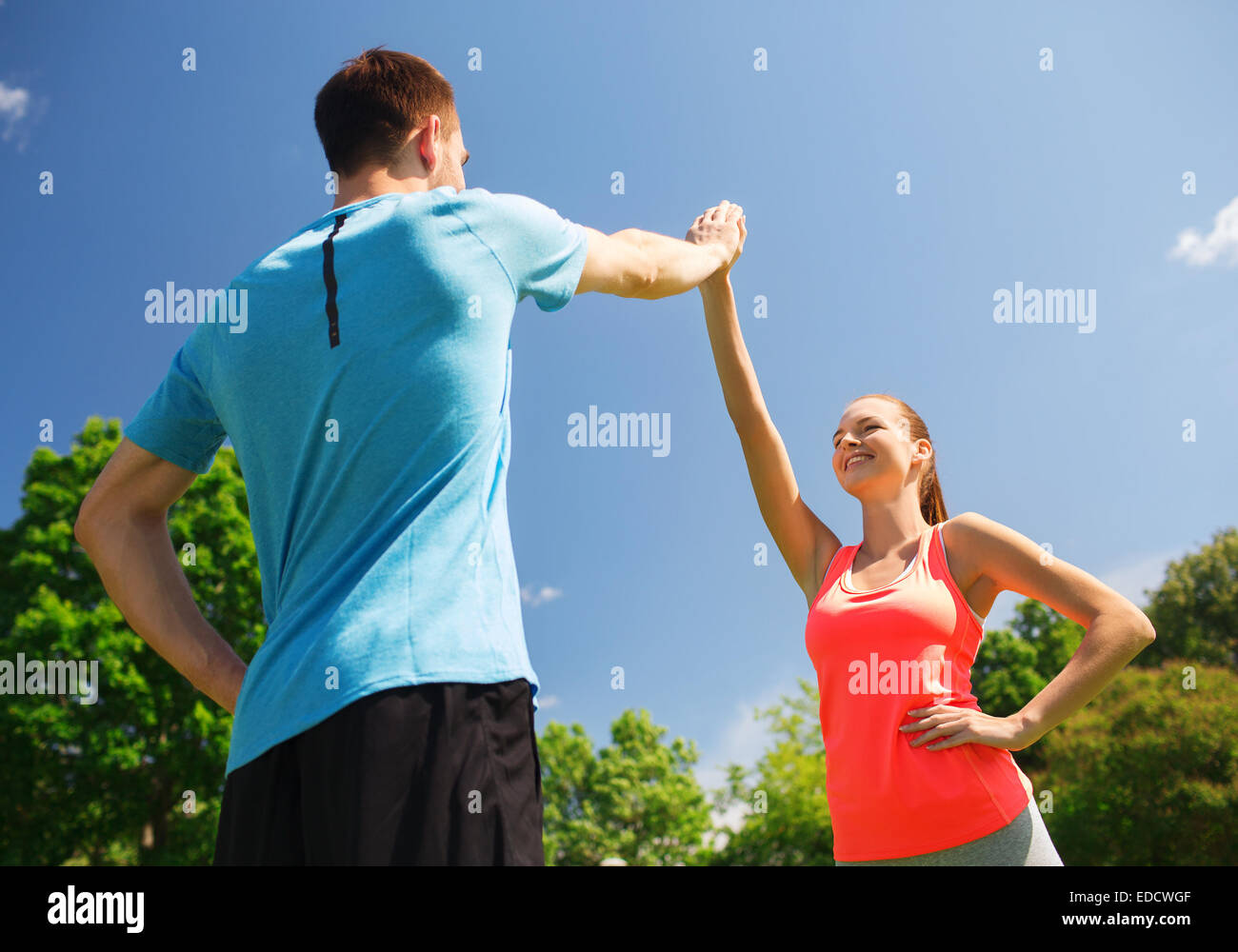two smiling people making high five outdoors Stock Photo - Alamy