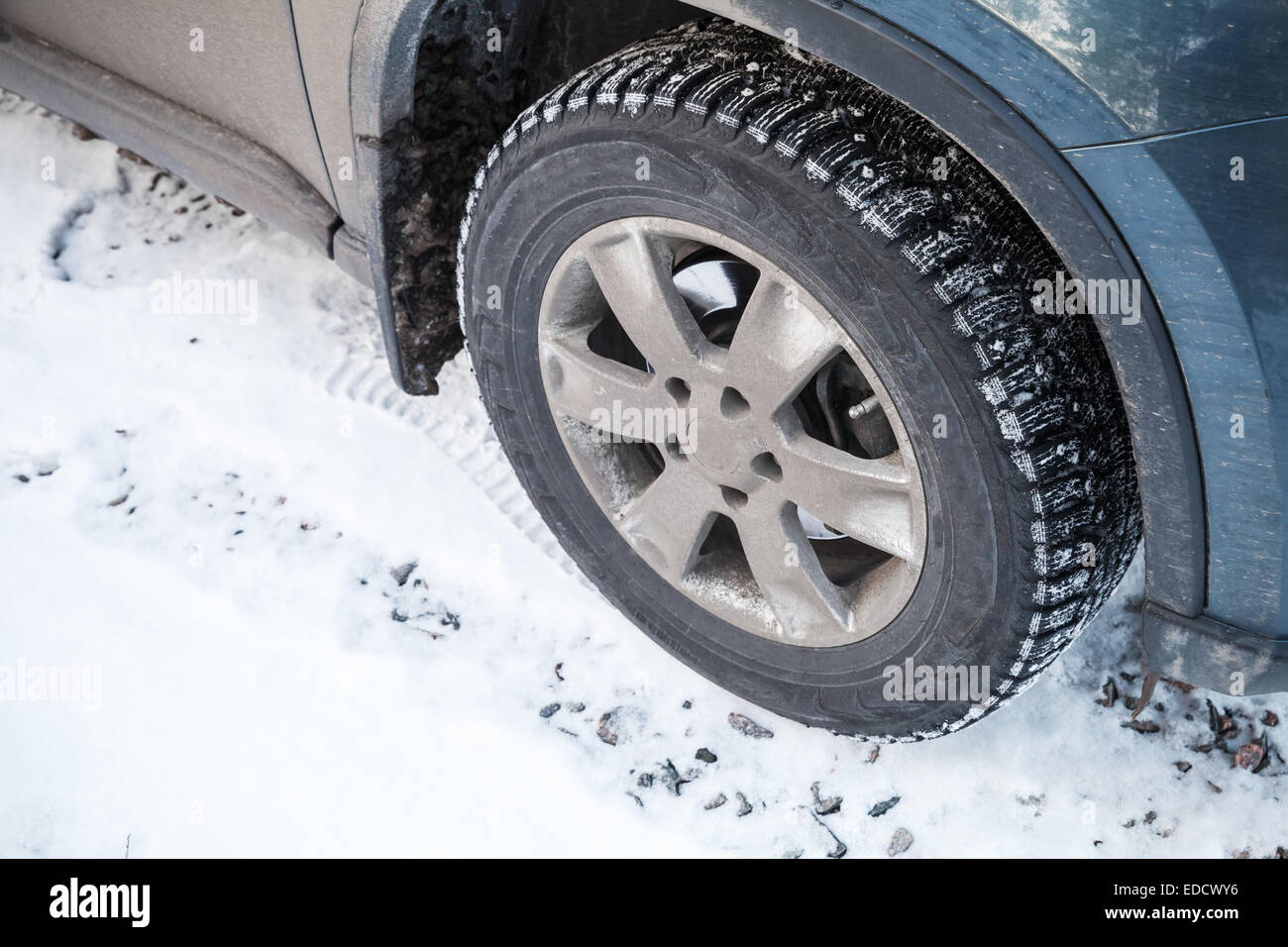 Modern automotive wheel with studded tires and winter road Stock Photo ...