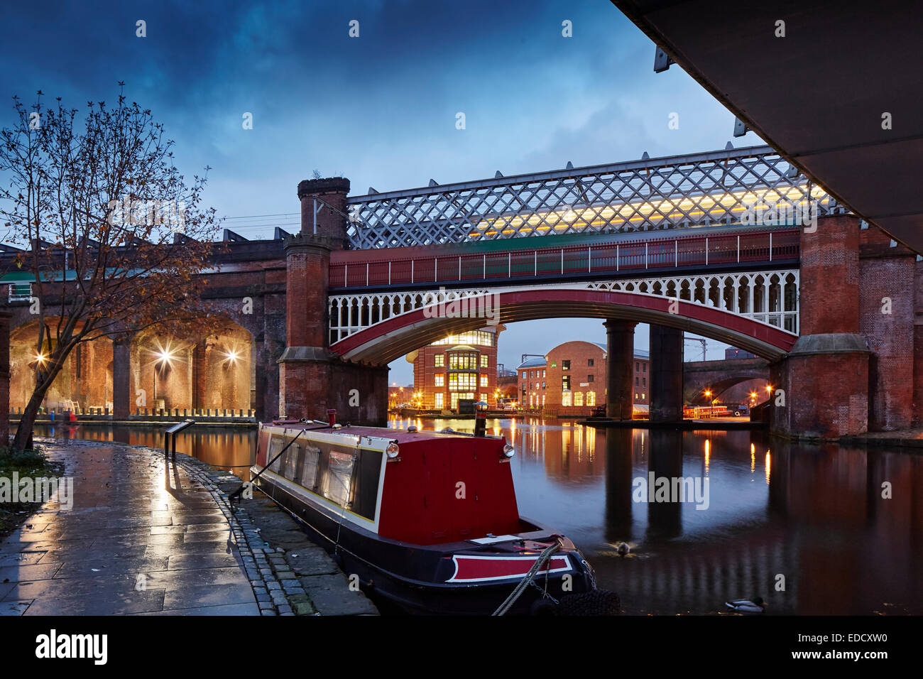 Castlefield Basin area of Manchester at dusk, a canal narrowboat mored ...