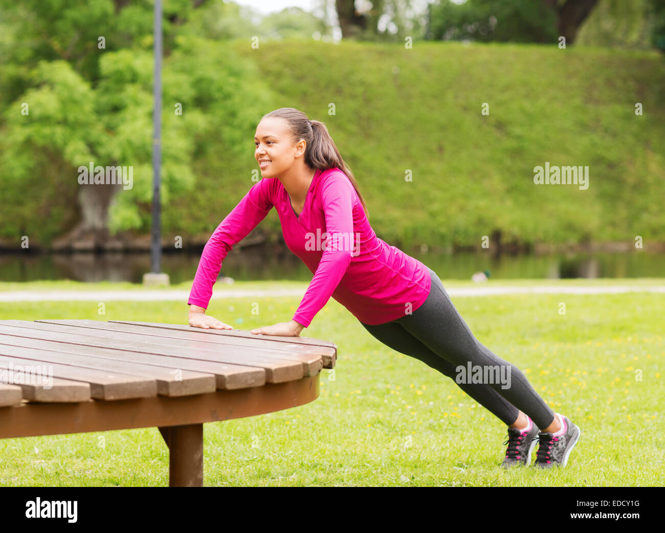 smiling woman doing push-ups on bench outdoors Stock Photo - Alamy