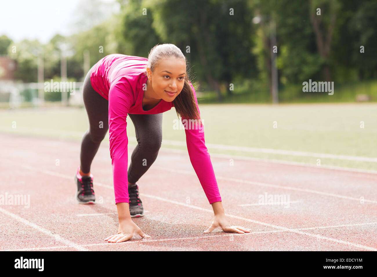 smiling young woman running on track outdoors Stock Photo - Alamy
