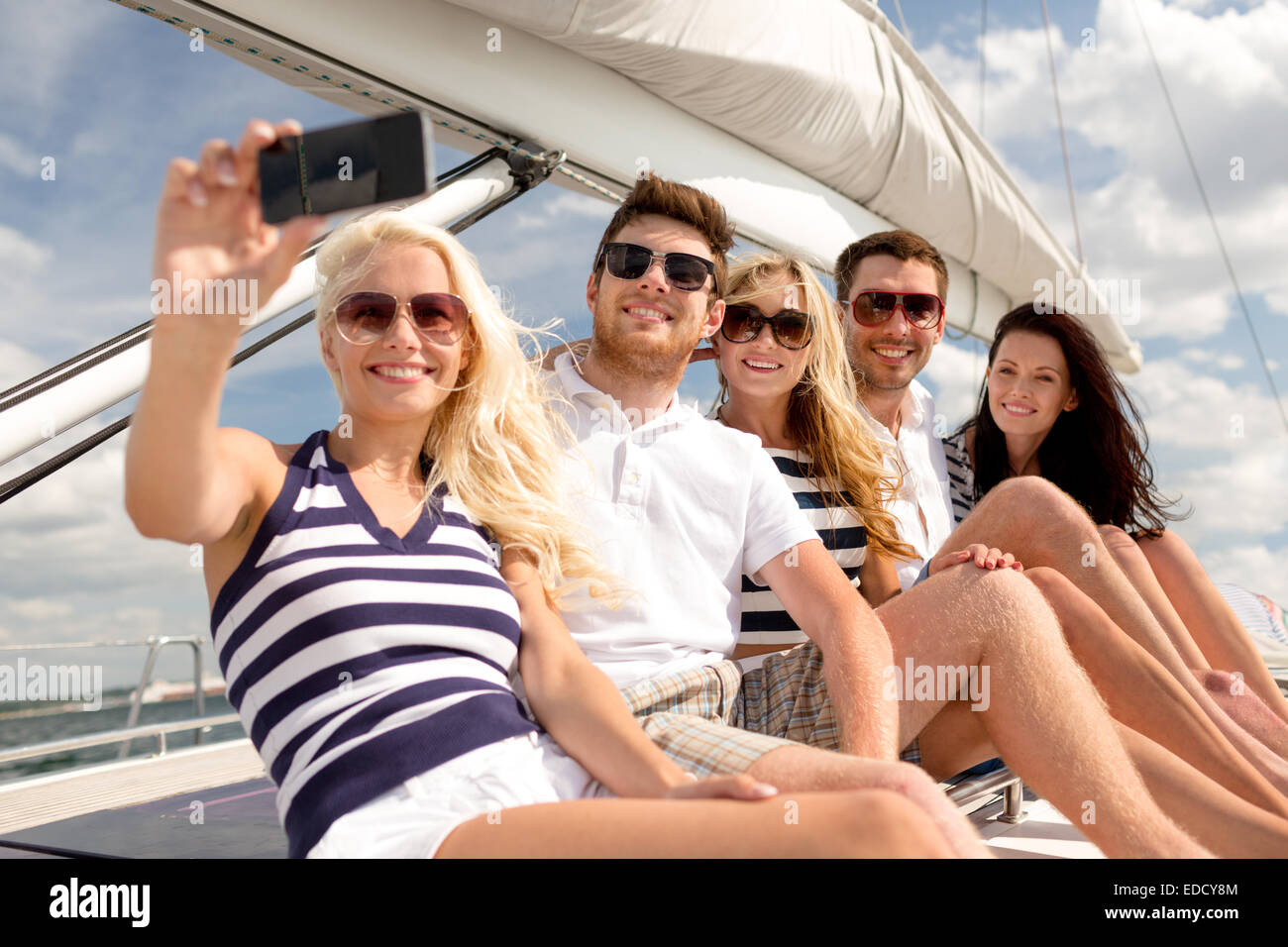 smiling friends sitting on yacht deck Stock Photo - Alamy