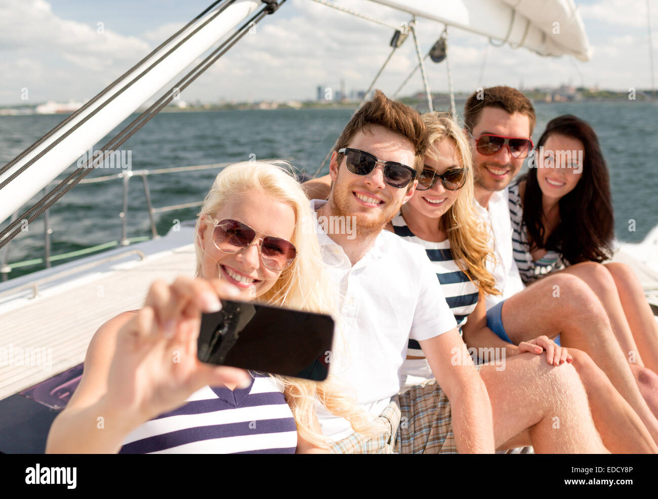 smiling friends sitting on yacht deck Stock Photo - Alamy