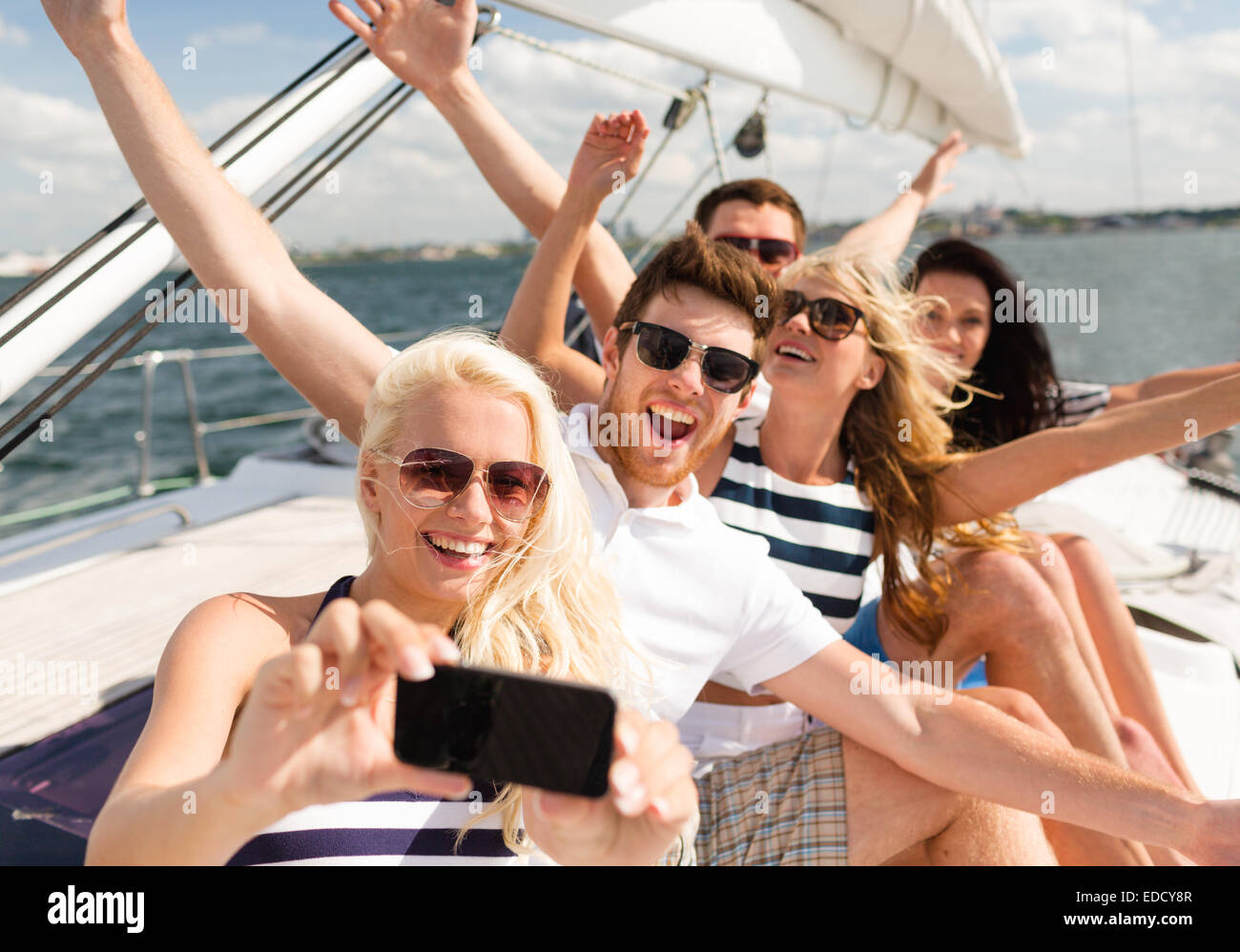 smiling friends sitting on yacht deck Stock Photo - Alamy