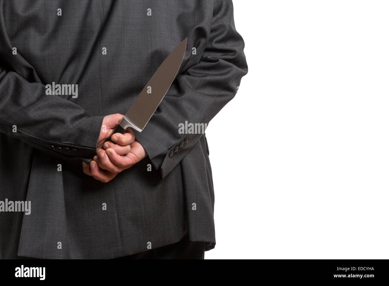 Man in suit hiding a large knife behind his back isolated on white ...