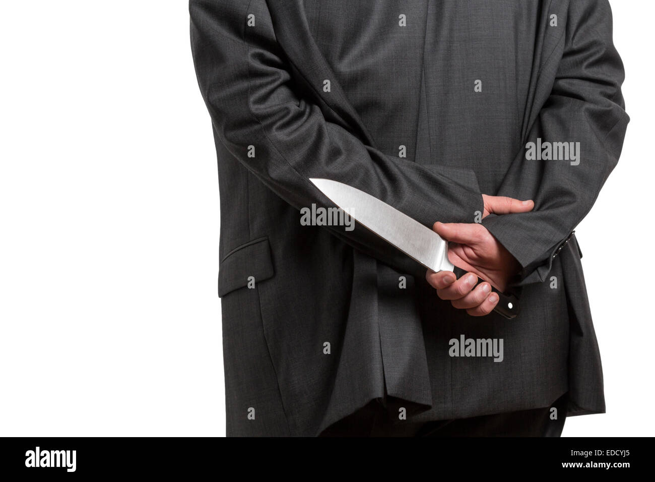 Man in suit hiding a large knife behind his back isolated on white ...