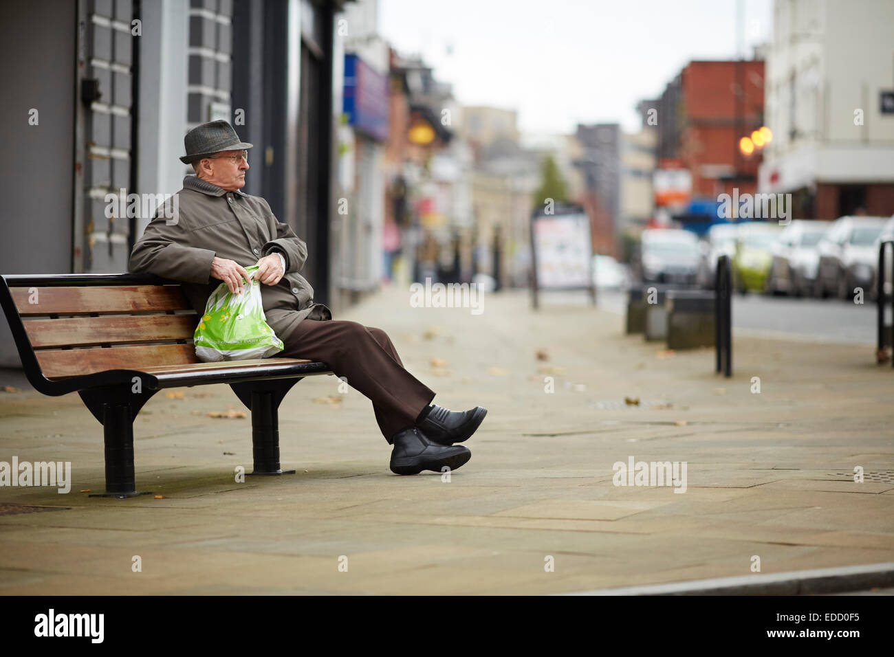 Stockport town centre Petersgate a man rests on a public street bench ...