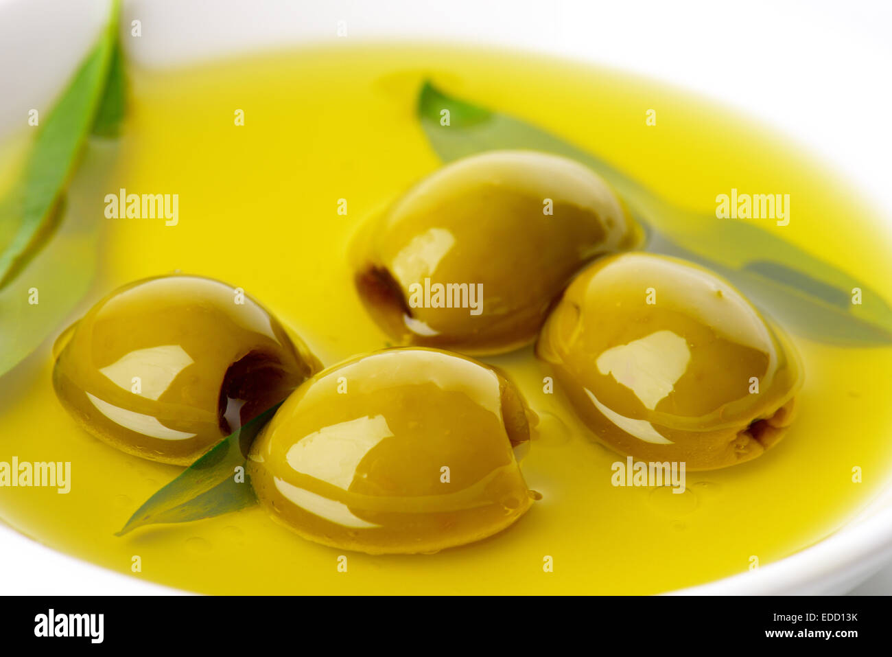Pitted green olives in oil Stock Photo - Alamy