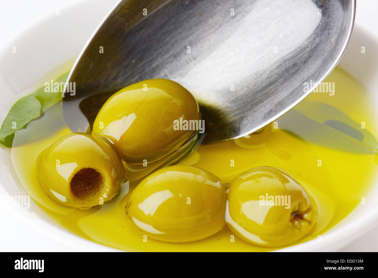 Pitted green olives in oil Stock Photo - Alamy