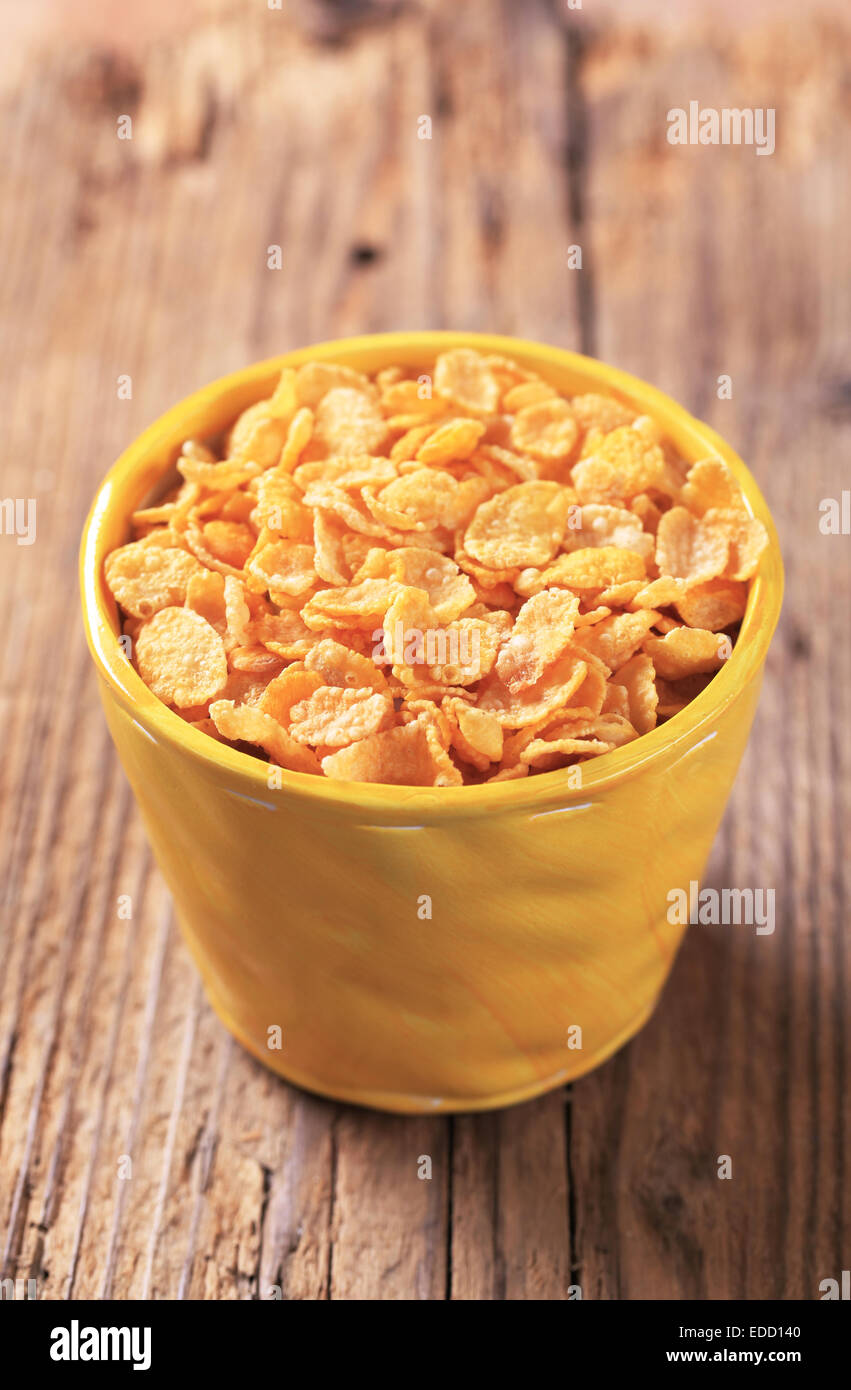 Crunchy corn flakes in yellow cup Stock Photo - Alamy