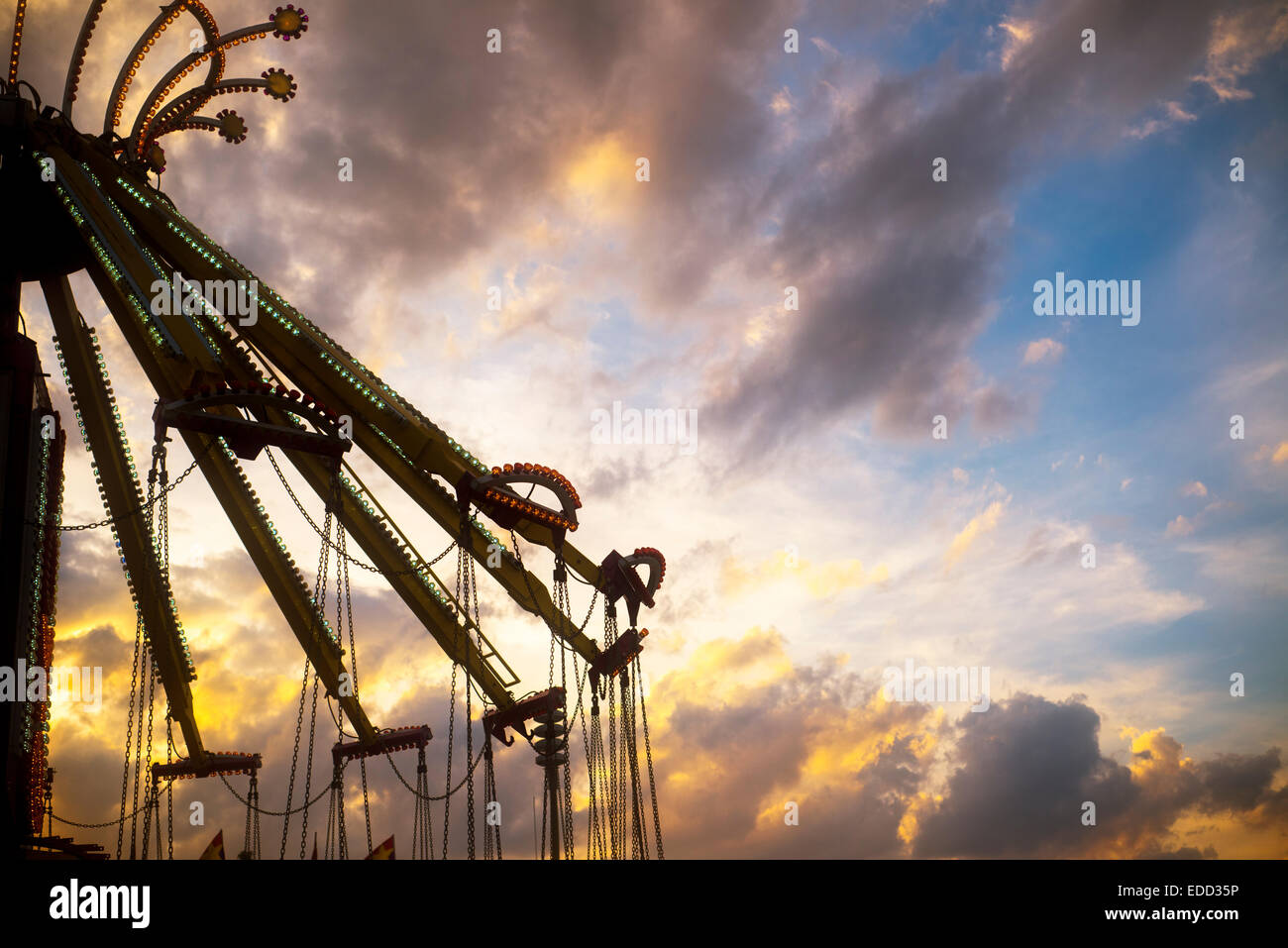 An amusement ride at a county fair stands idle against the sunset Stock ...