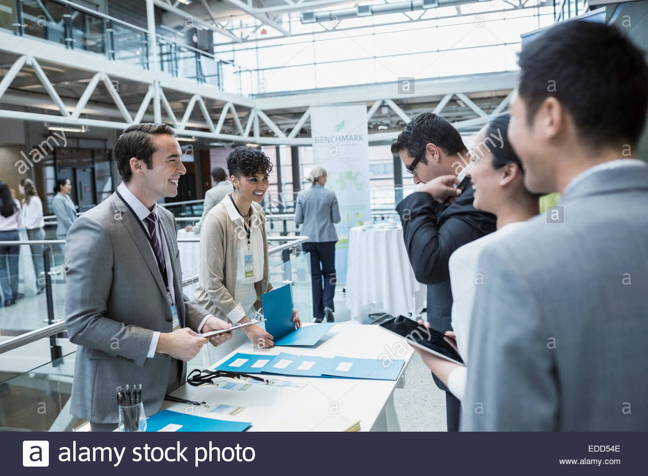 Business people checking in at conference registration table Stock ...