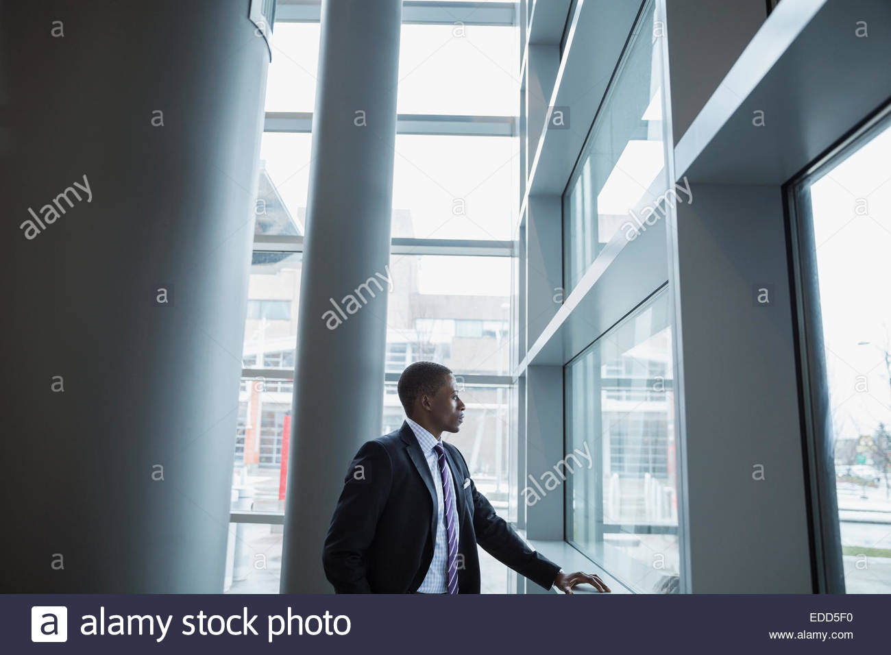 Pensive businessman looking out window Stock Photo - Alamy