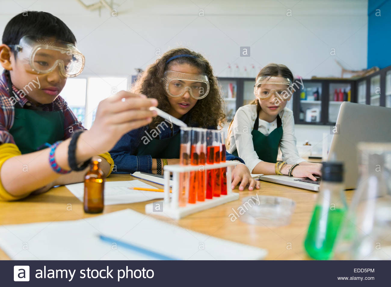Elementary students conducting scientific experiment in laboratory ...
