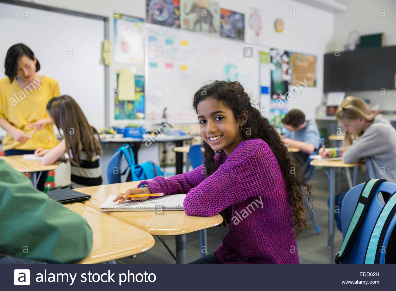 Portrait of confident student at desk in classroom Stock Photo - Alamy