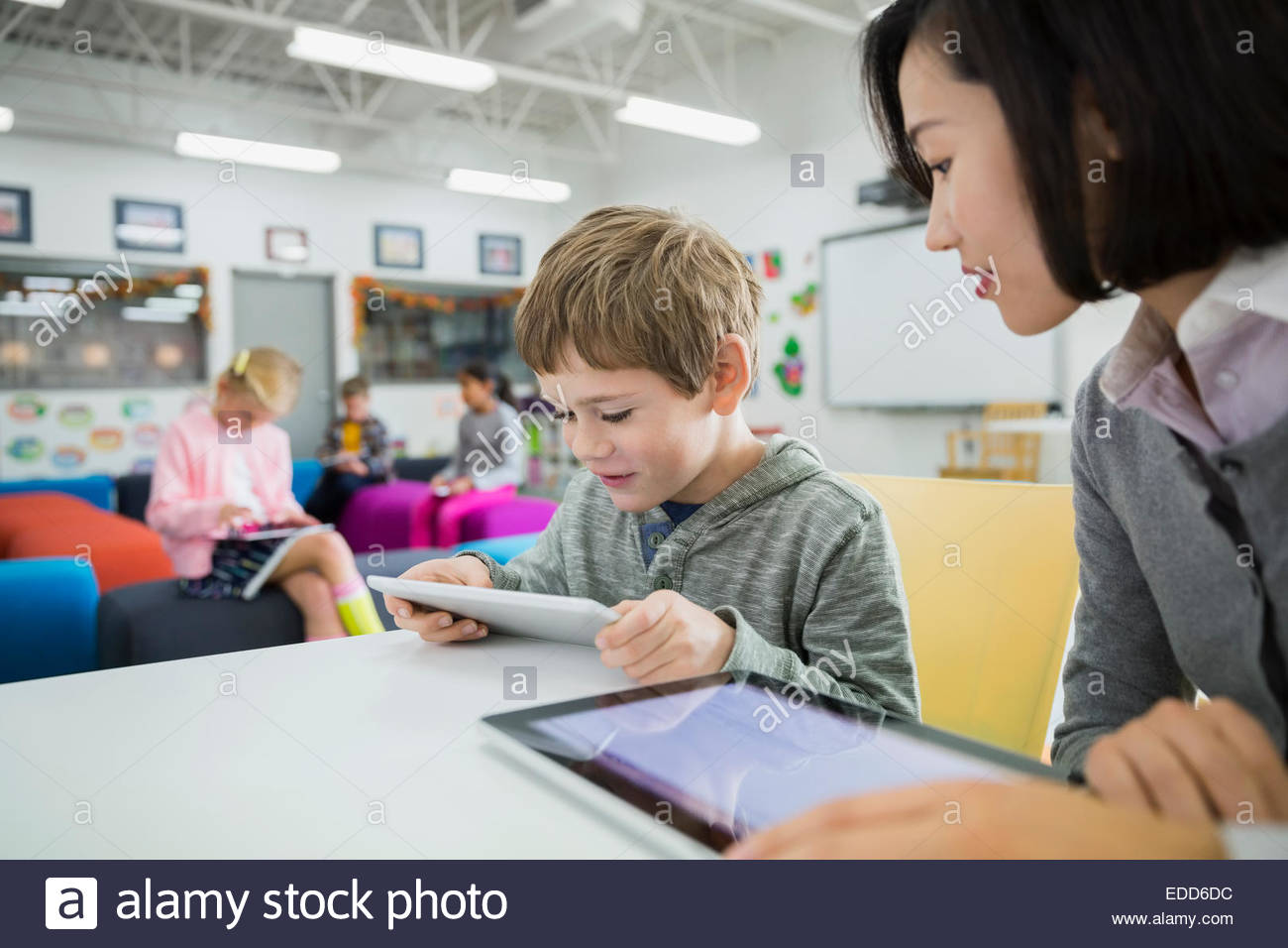 Teacher and elementary student using digital tablets Stock Photo - Alamy