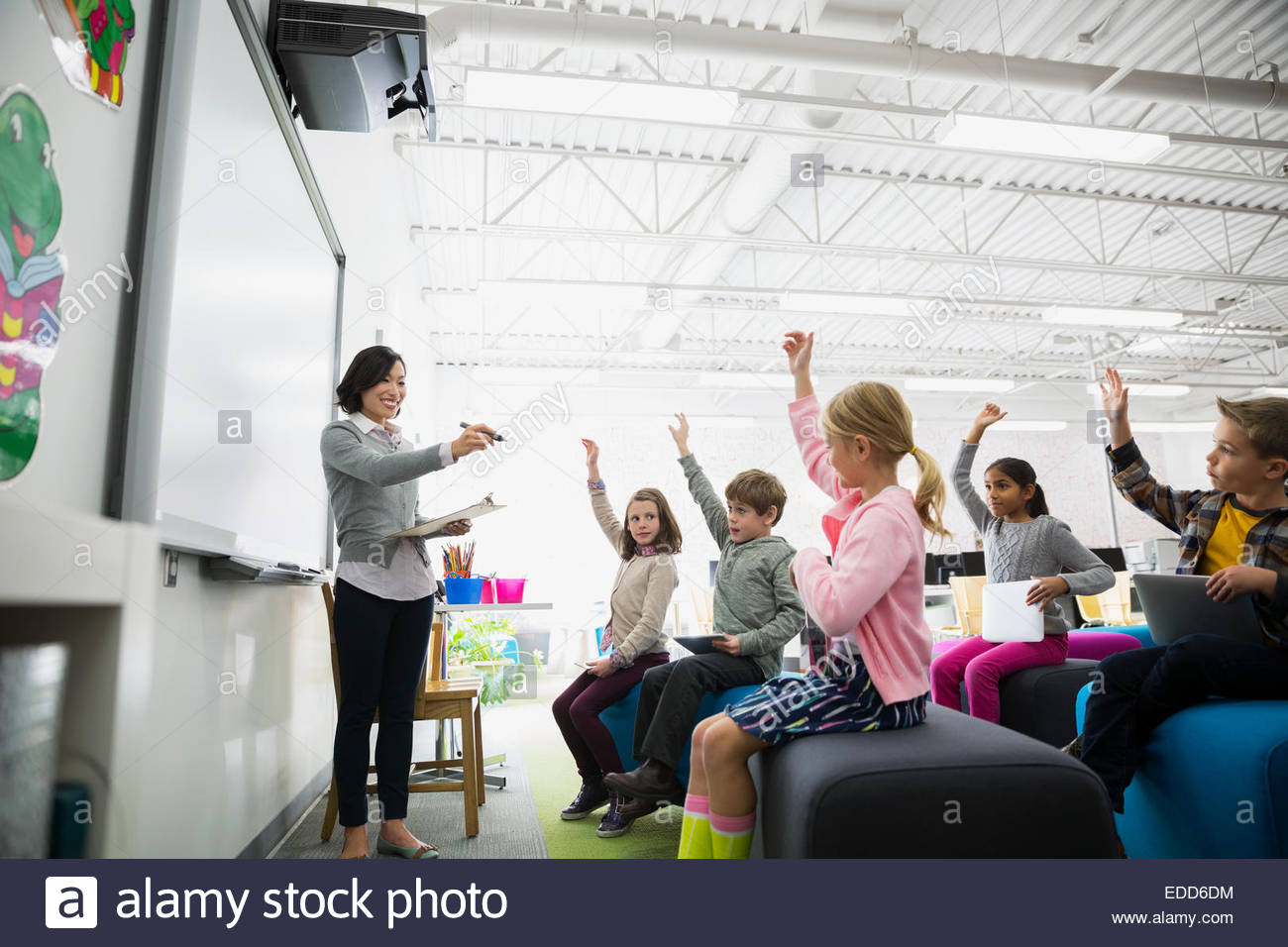 Teacher pointing boy raised hand hi-res stock photography and images ...