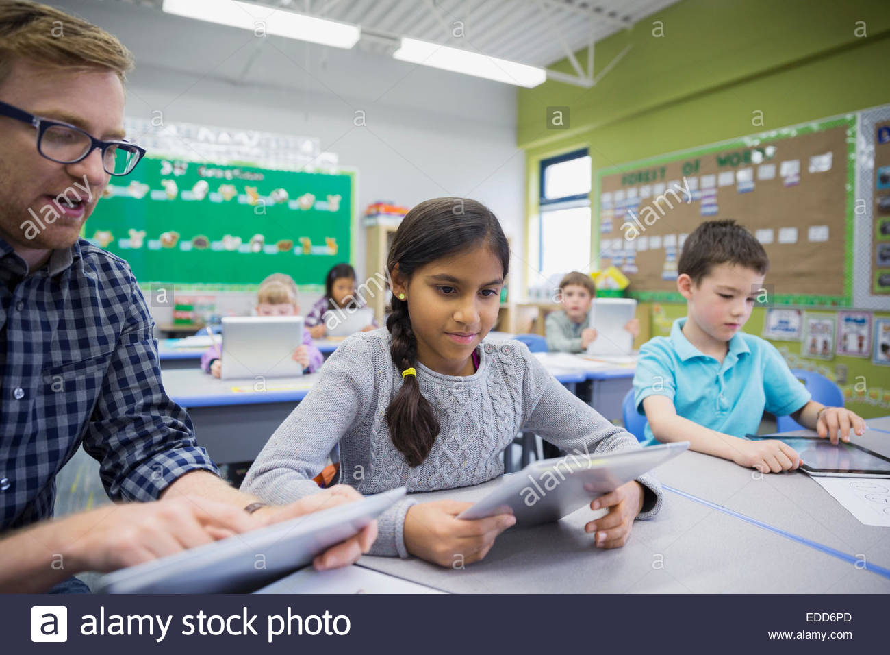 Teacher and elementary students using digital tablets Stock Photo - Alamy