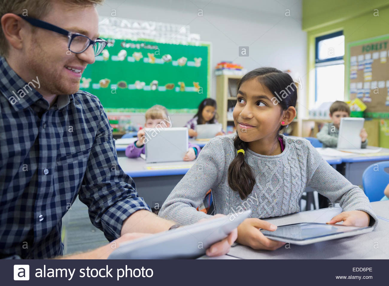 Teacher and elementary student using digital tablets Stock Photo - Alamy