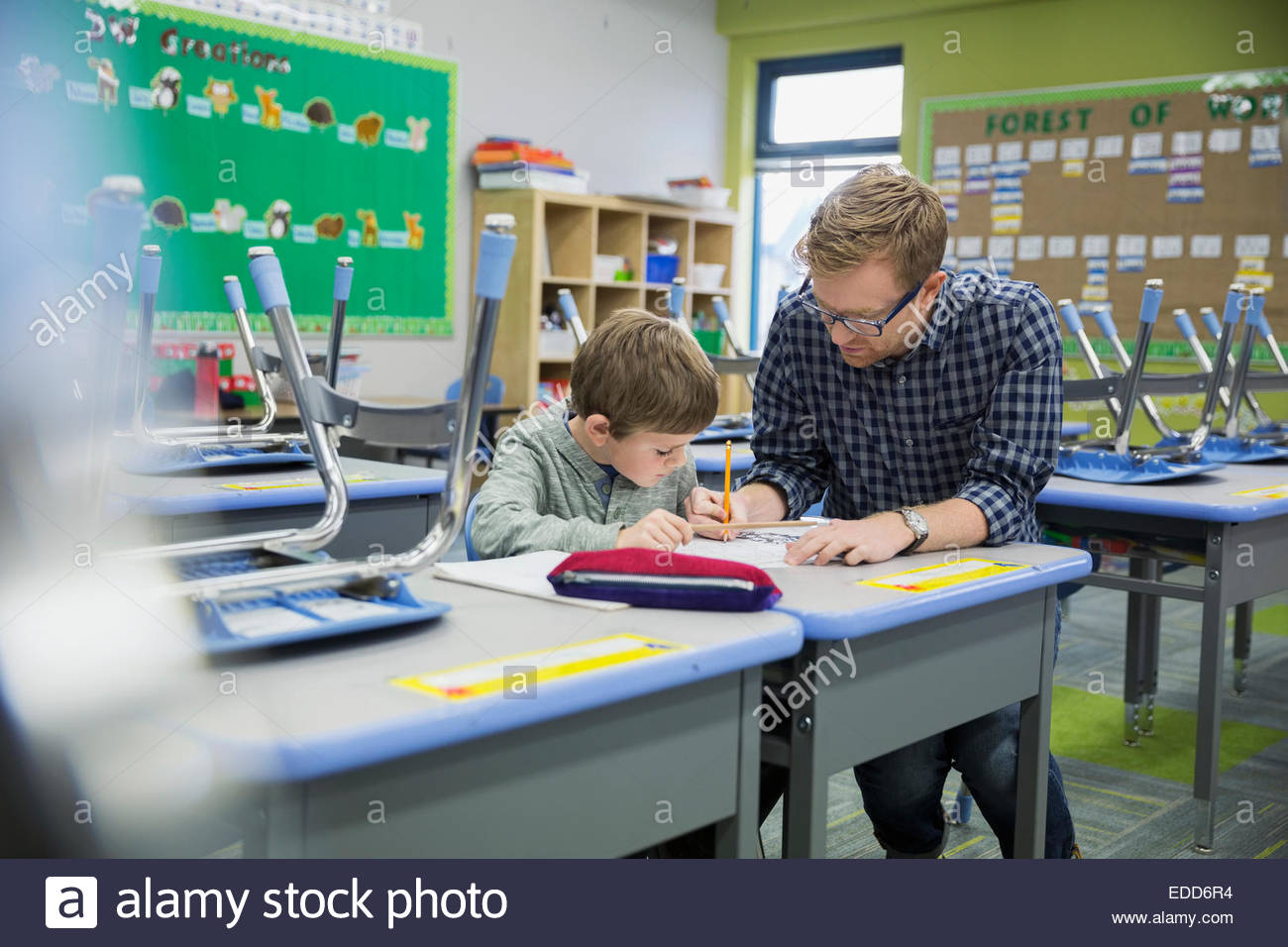 Teacher helping elementary student in hi-res stock photography and ...