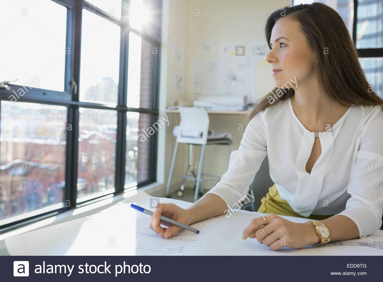Pensive architect looking out office window Stock Photo - Alamy