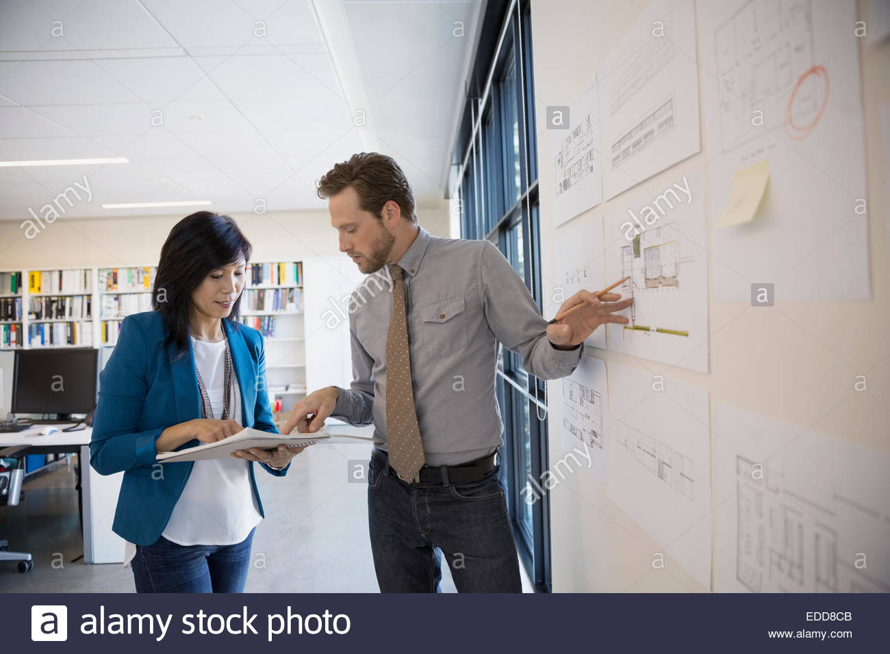 Architects discussing plans at wall Stock Photo - Alamy